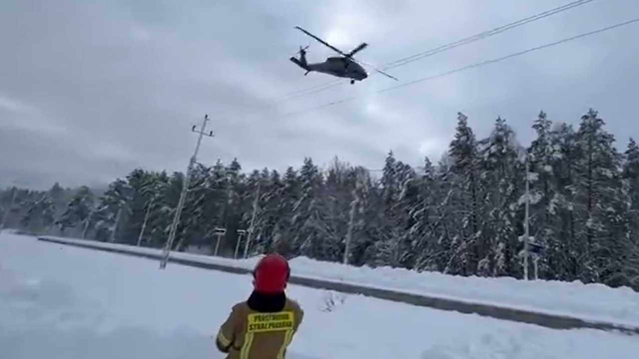 Police Black Hawk chopper clears snow from treetops in Poland